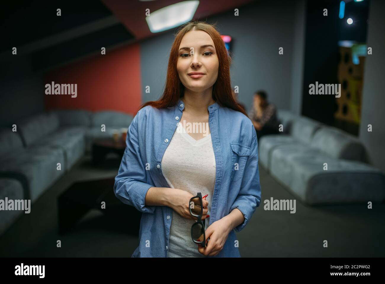 Female spectator with 3d glasses poses in cinema hall before the ...