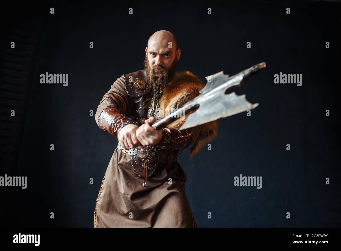 Angry viking with axe dressed in traditional nordic clothes, barbarian ...