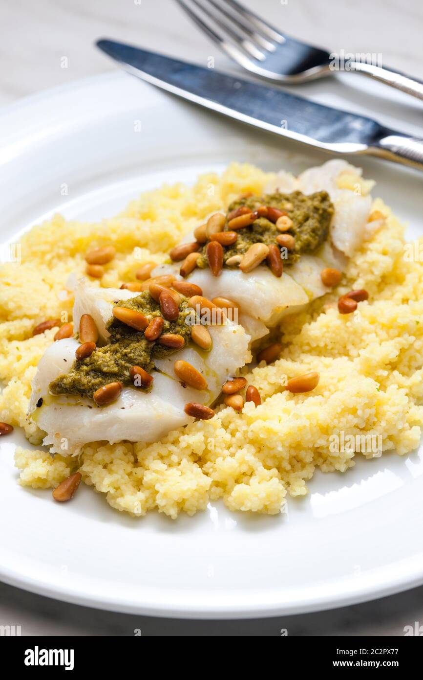 cod with green pesto and pine seeds with couscous Stock Photo - Alamy