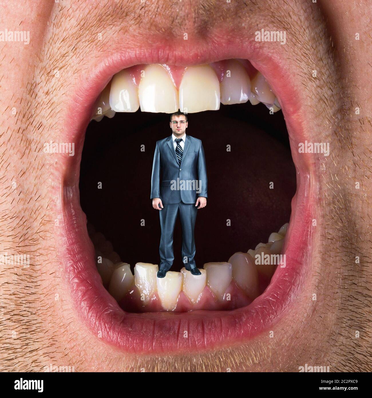 Small businessman standing in open mouth Stock Photo - Alamy