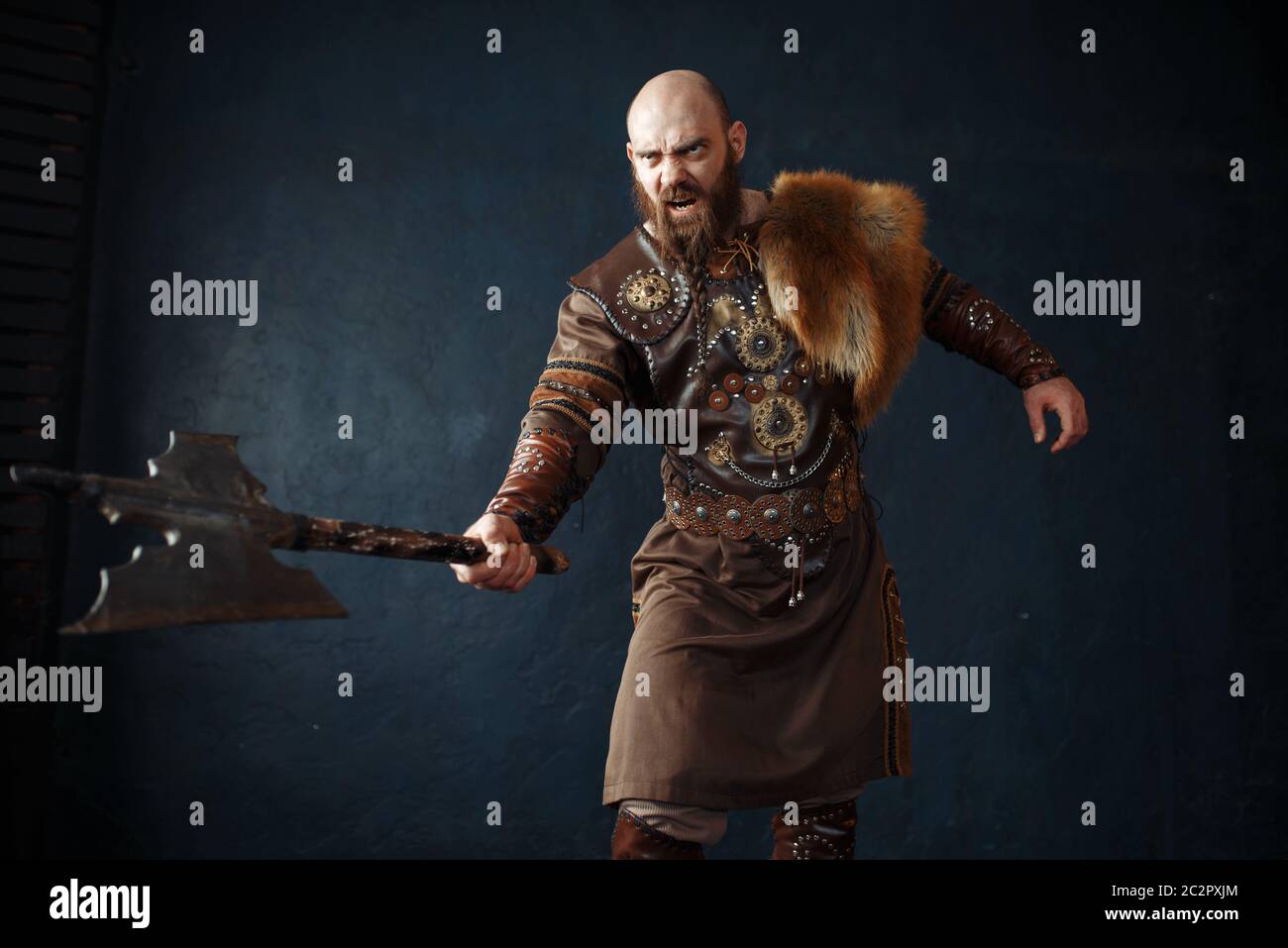 Angry viking with axe dressed in traditional nordic clothes, barbarian ...