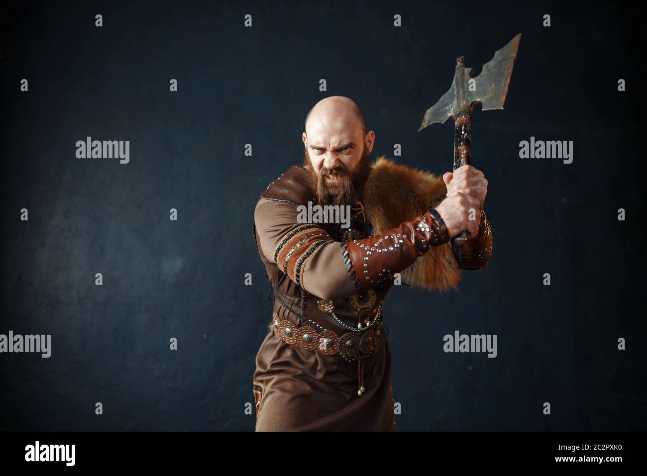 Angry viking with axe dressed in traditional nordic clothes, barbarian ...