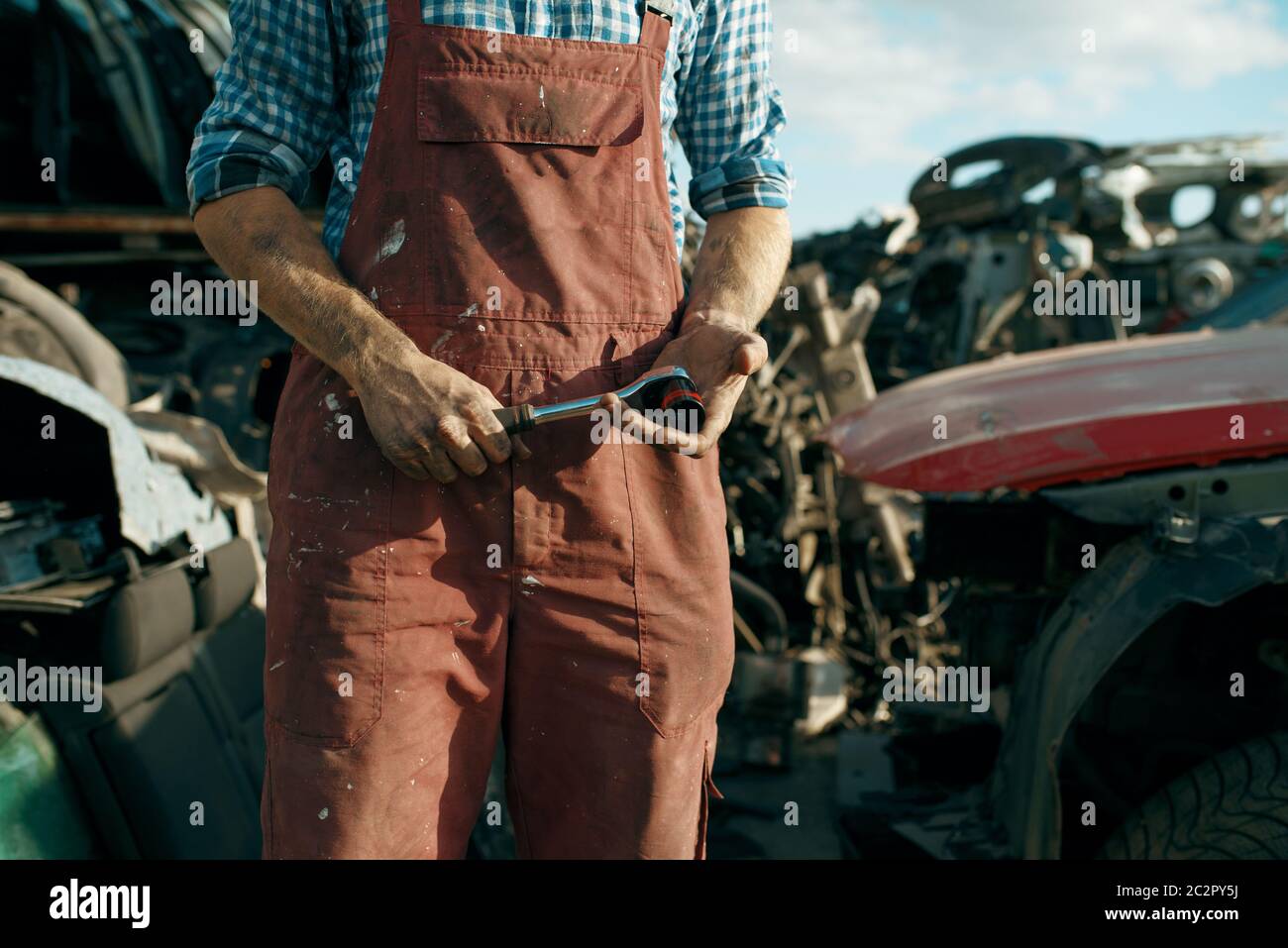 Male Mechanic In Welding Glasses On Car Junkyard Auto Scrap Vehicle