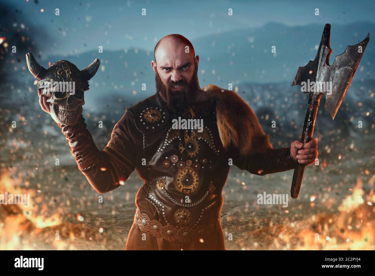 Angry viking dressed in traditional nordic clothes holds axe and human ...