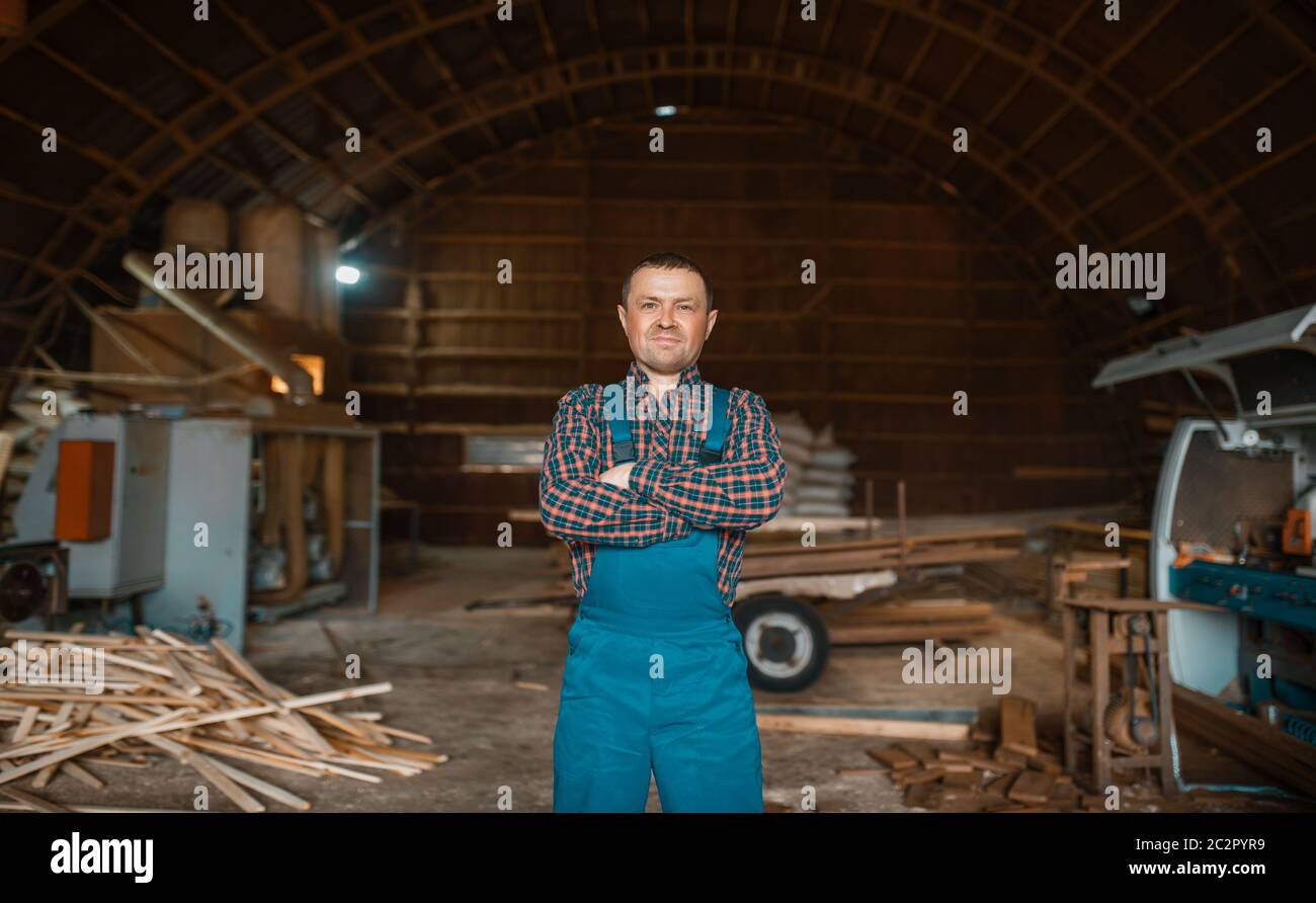 Woodworker in uniform at his workplace on lumbermill, woodworking ...