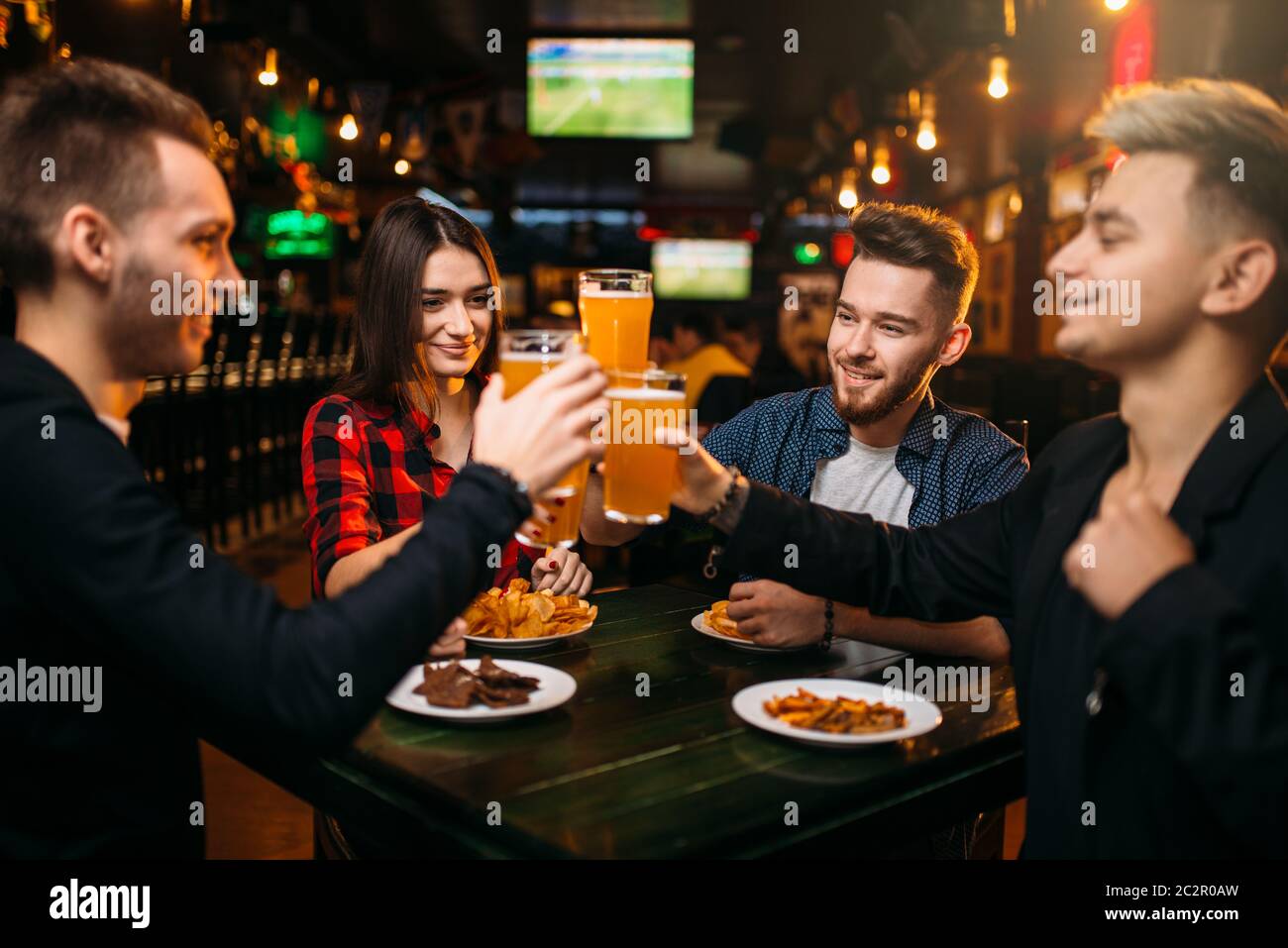 Group of friends having fun in a sport bar and drinks beer, happy ...