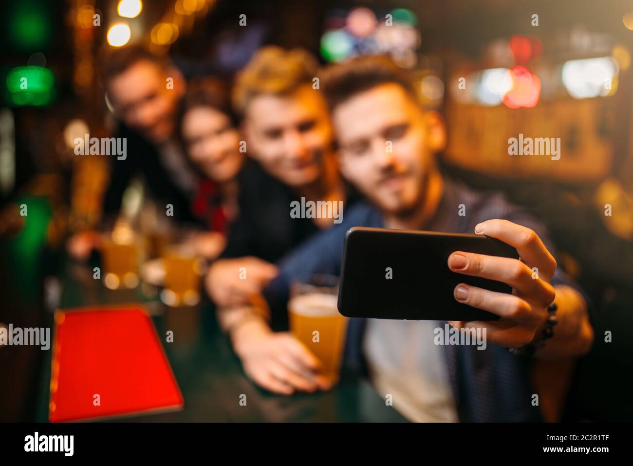 Happy football fans makes selfie on phone camera at the bar counter in ...
