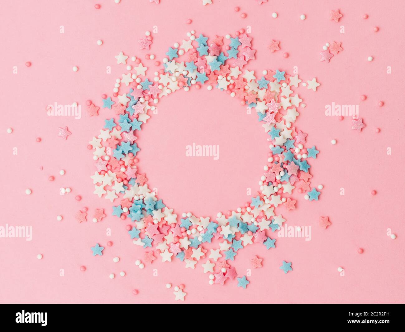 Festive border frame of colorful pastel sprinkles on pink background ...