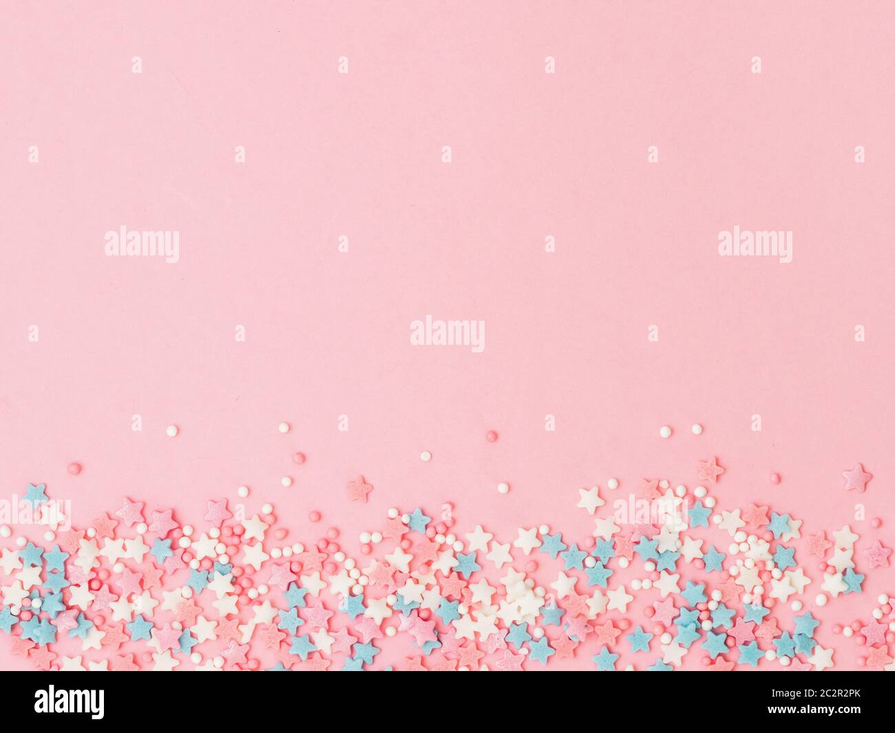 Festive border frame of colorful pastel sprinkles on pink background ...
