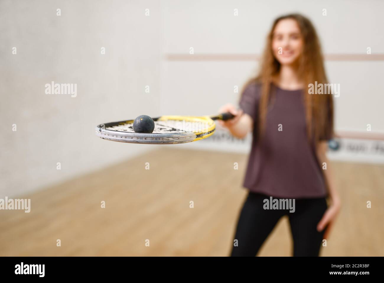 Female person shows squash racket and ball. Girl on game training ...