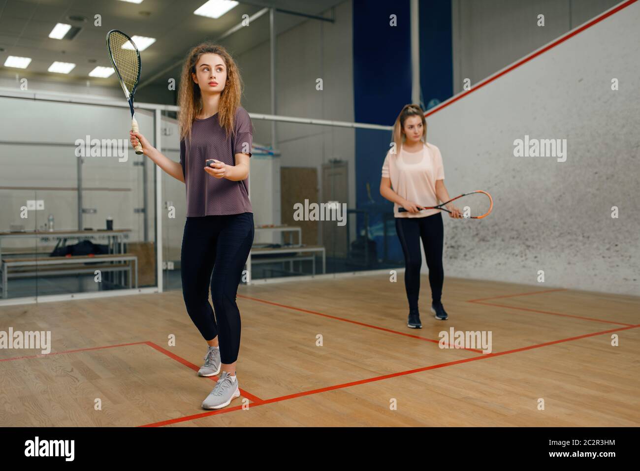 Two female players with squash racket playing on court. Girl on game ...
