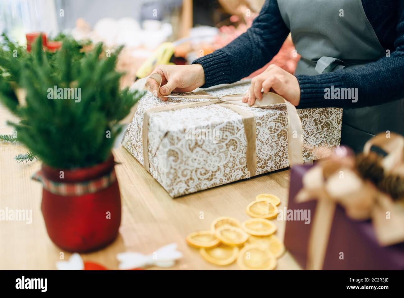 Female person ties a gold bow on gift box, handmade wrapping and ...