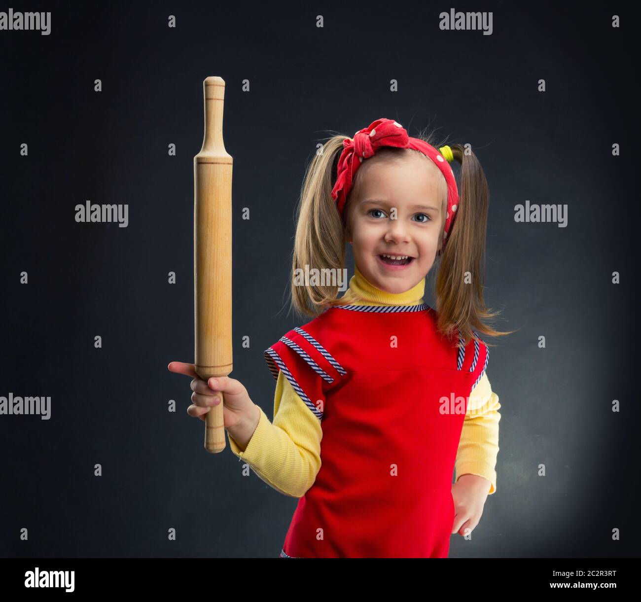 Happy blond girl with rolling-pin smiling Stock Photo - Alamy