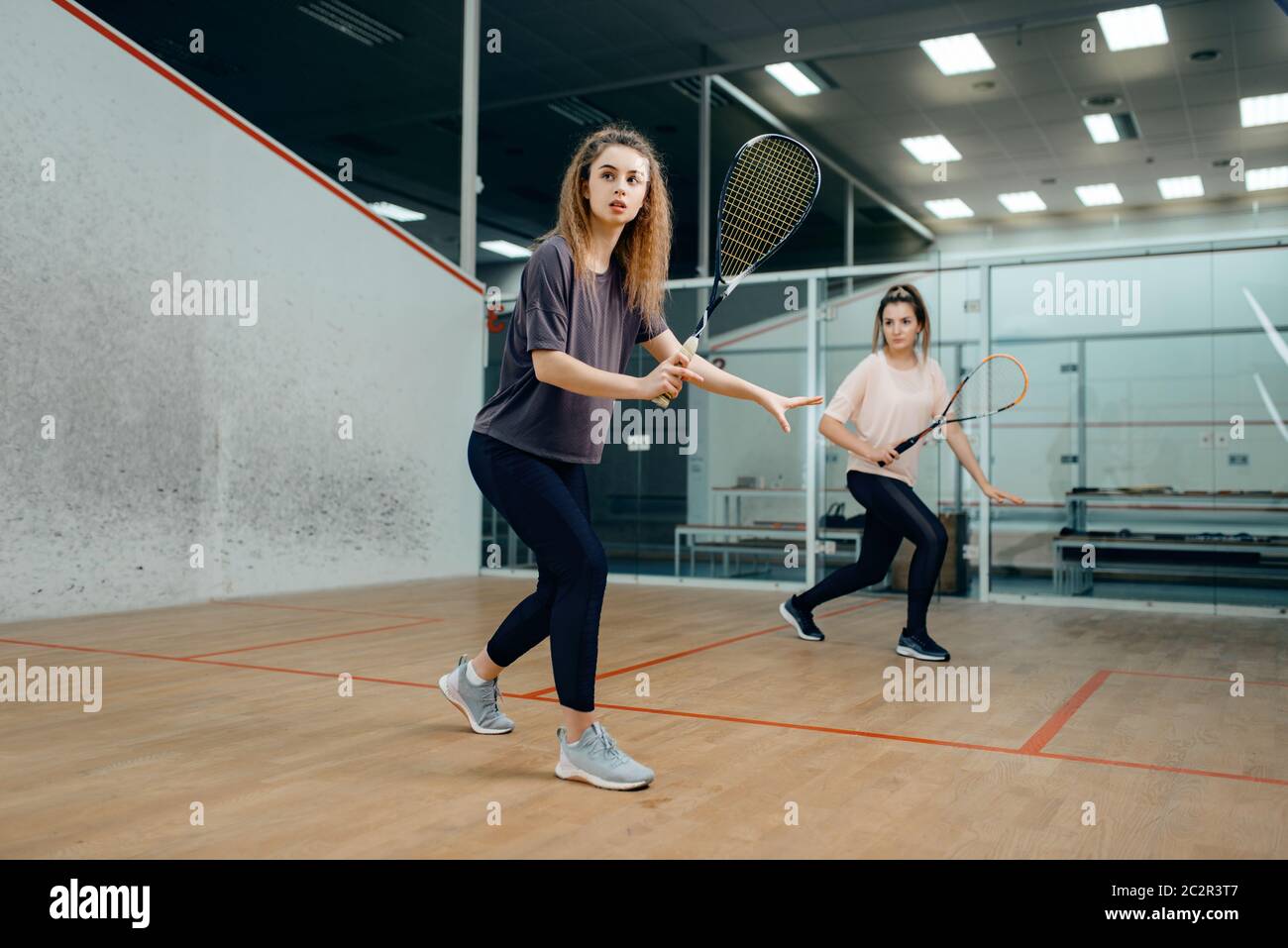 Two female players with squash racket playing on court. Girl on game ...