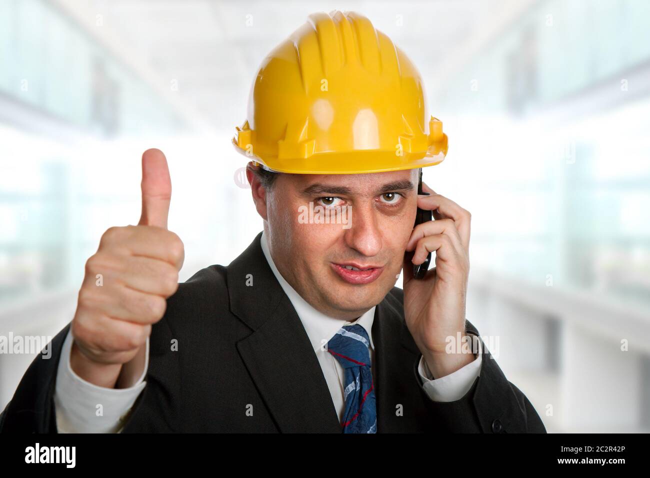 An engineer with yellow hat going thumbs up Stock Photo - Alamy