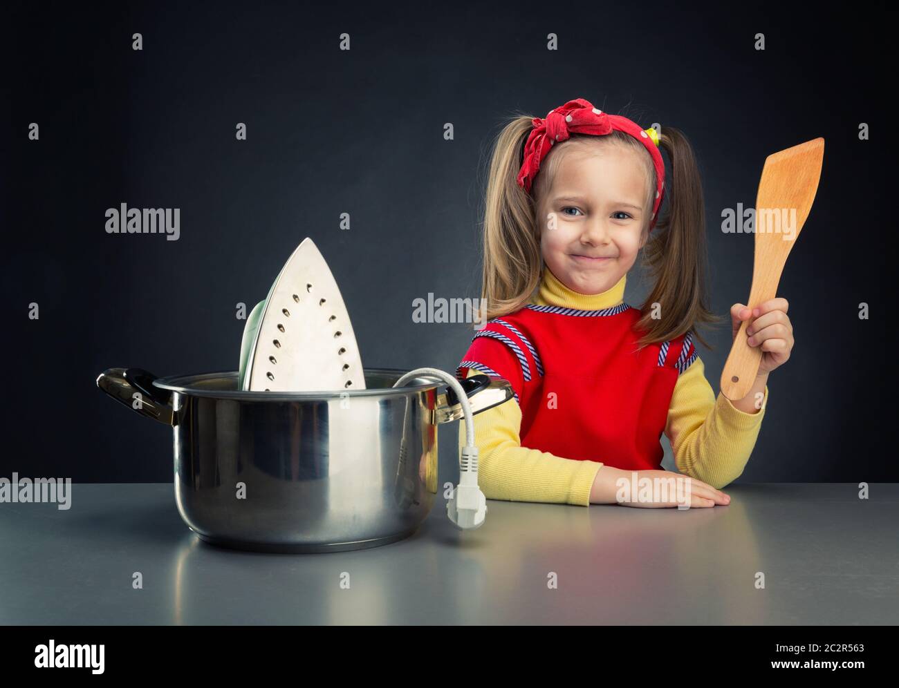 Cute smiling little girl cooking an iron in the pot Stock Photo - Alamy