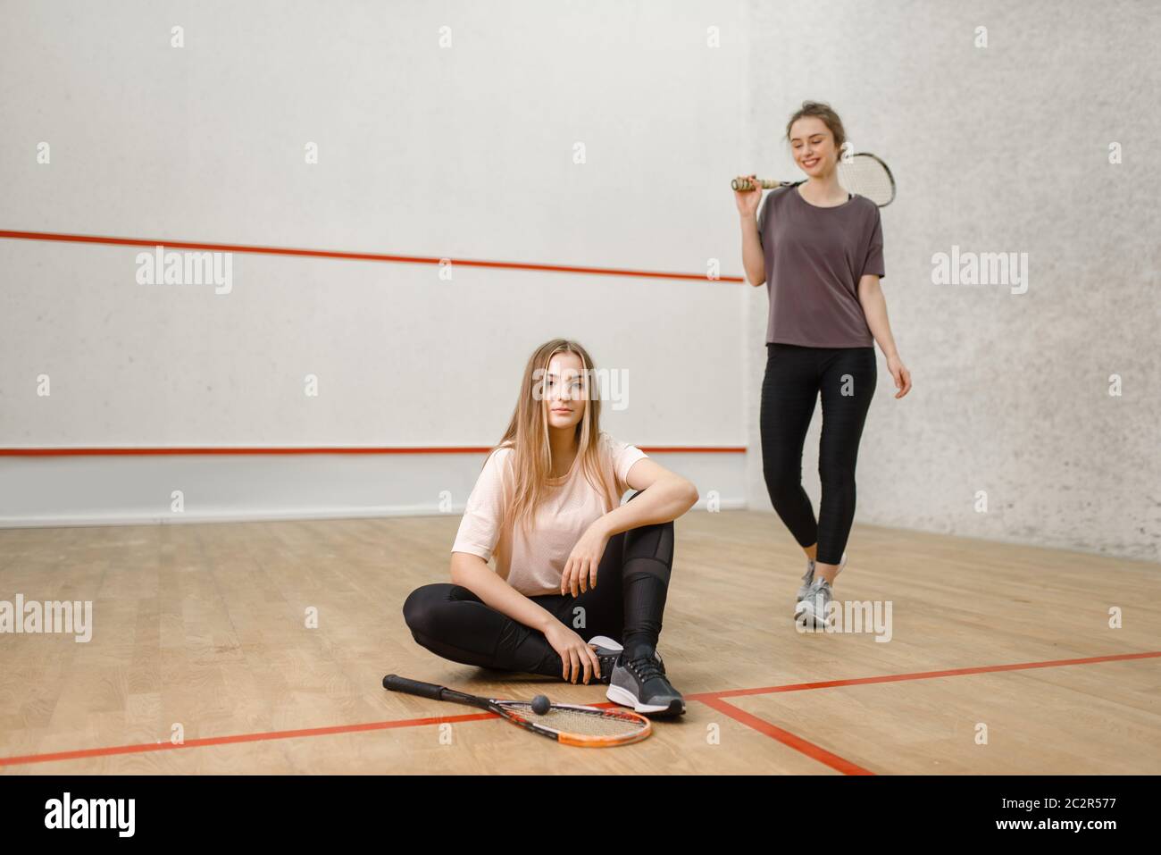 Two female squash players poses on court. Youth on training, active ...