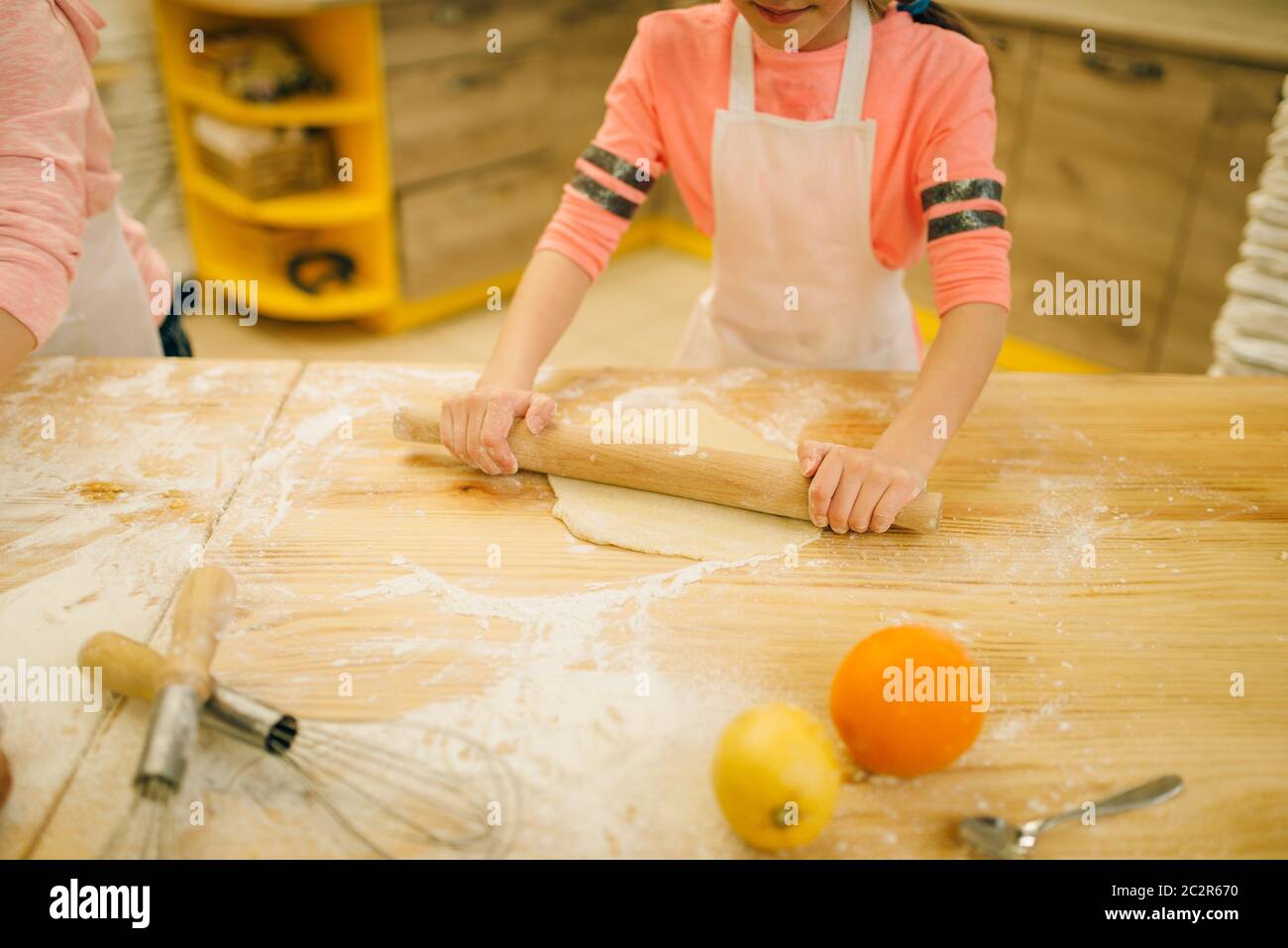 Little girl chef hands roll out the dough with rolling pin, cookies ...