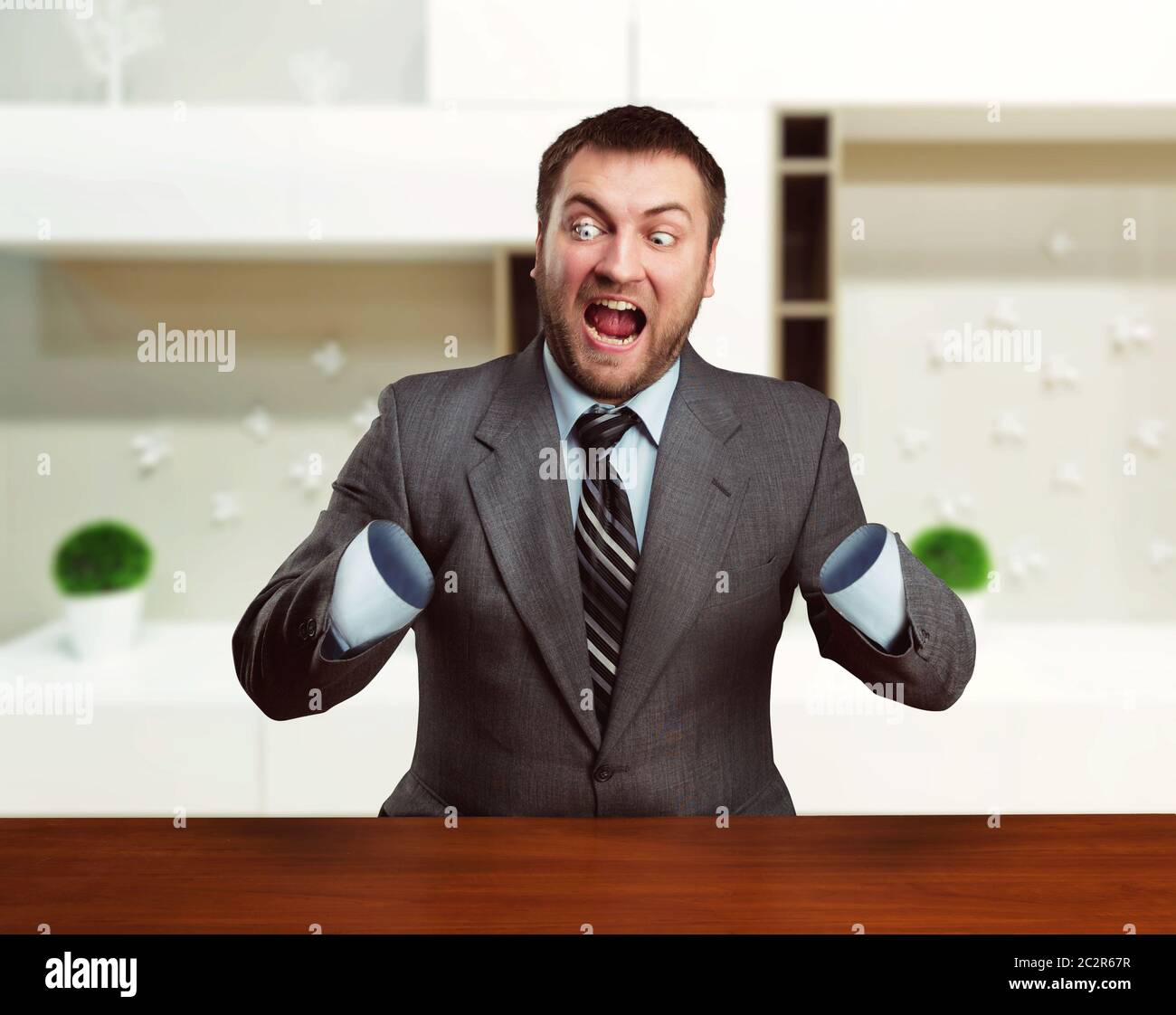 Scared businessman without arms sits at the table Stock Photo - Alamy