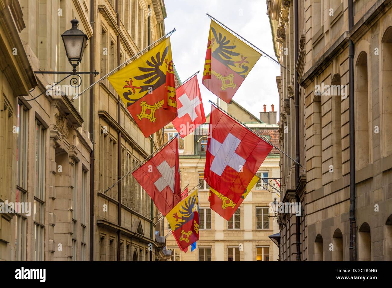 Flags fluttering in the narrow streets of Old Geneva showcasing local ...