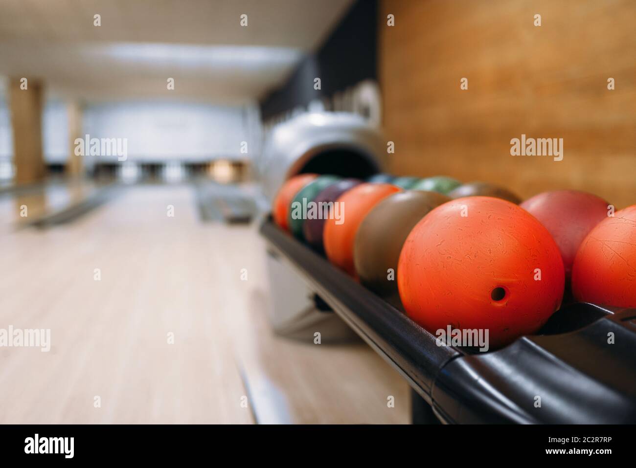 Color bowling balls in feeder, lane with pins on background, nobody ...