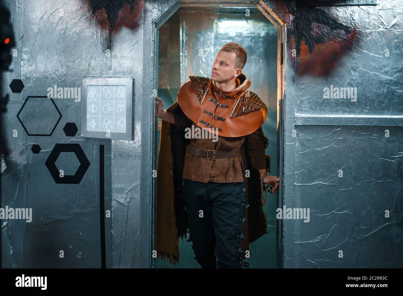Space traveler looks out of the teleport with foil walls. Fantasy ...