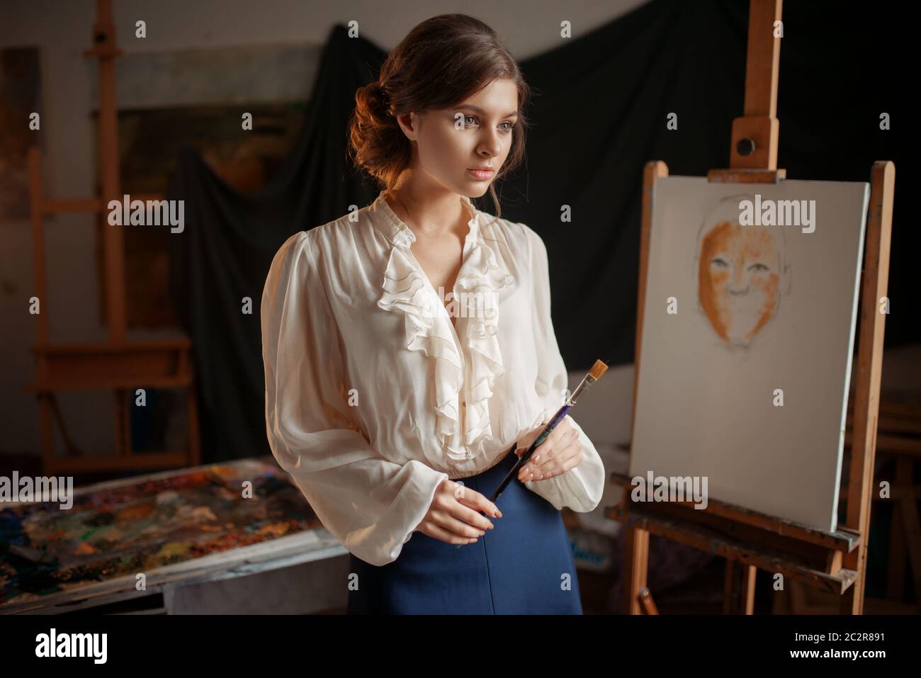 Female painter drawing with color palette and brush in studio. Creative ...