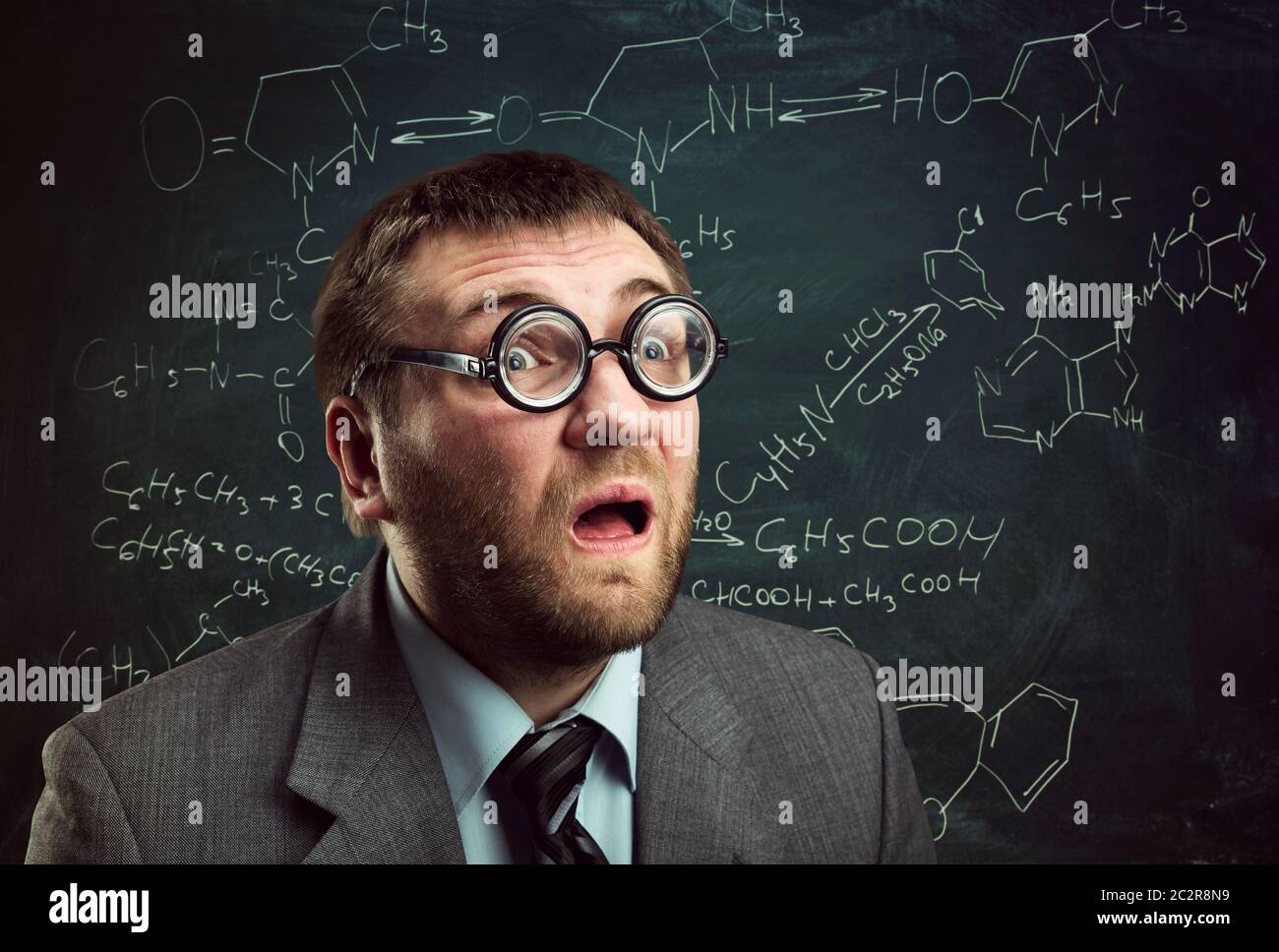 Bizarre professor in glasses thinking over chemical formulas on ...