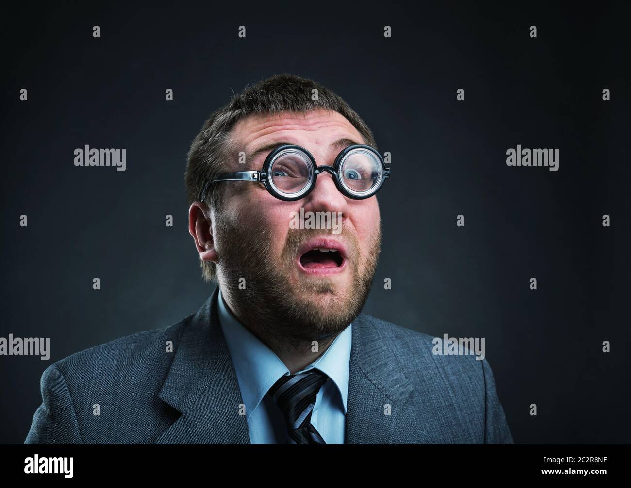 Surprised nerd businessman in glasses over grey Stock Photo - Alamy