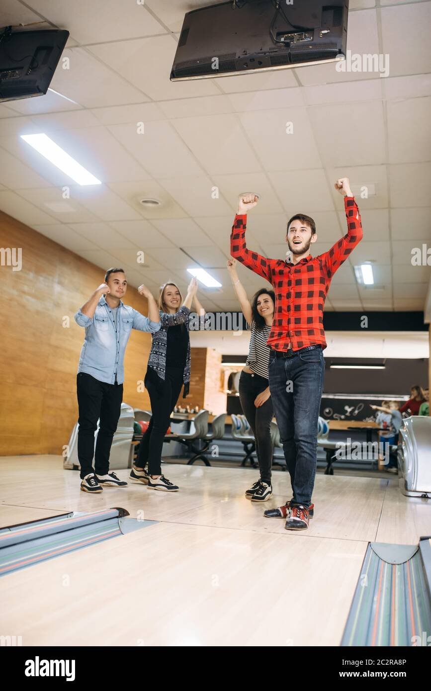 Male bowler cheers holding hands up, he just makes strike shot. Bowling ...