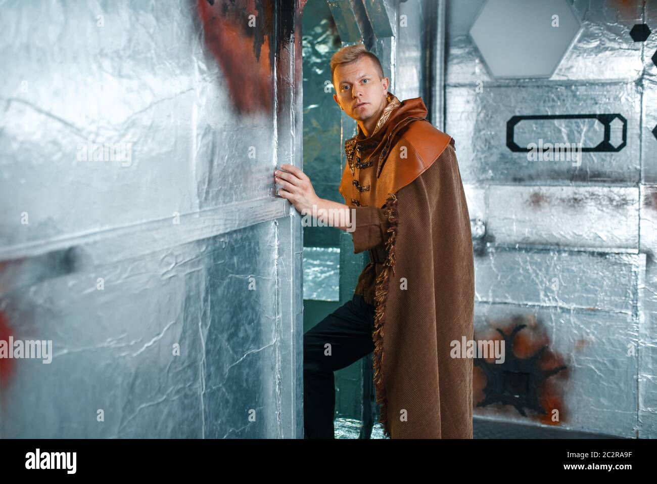 Space traveler looks out of the teleport with foil walls. Fantasy ...