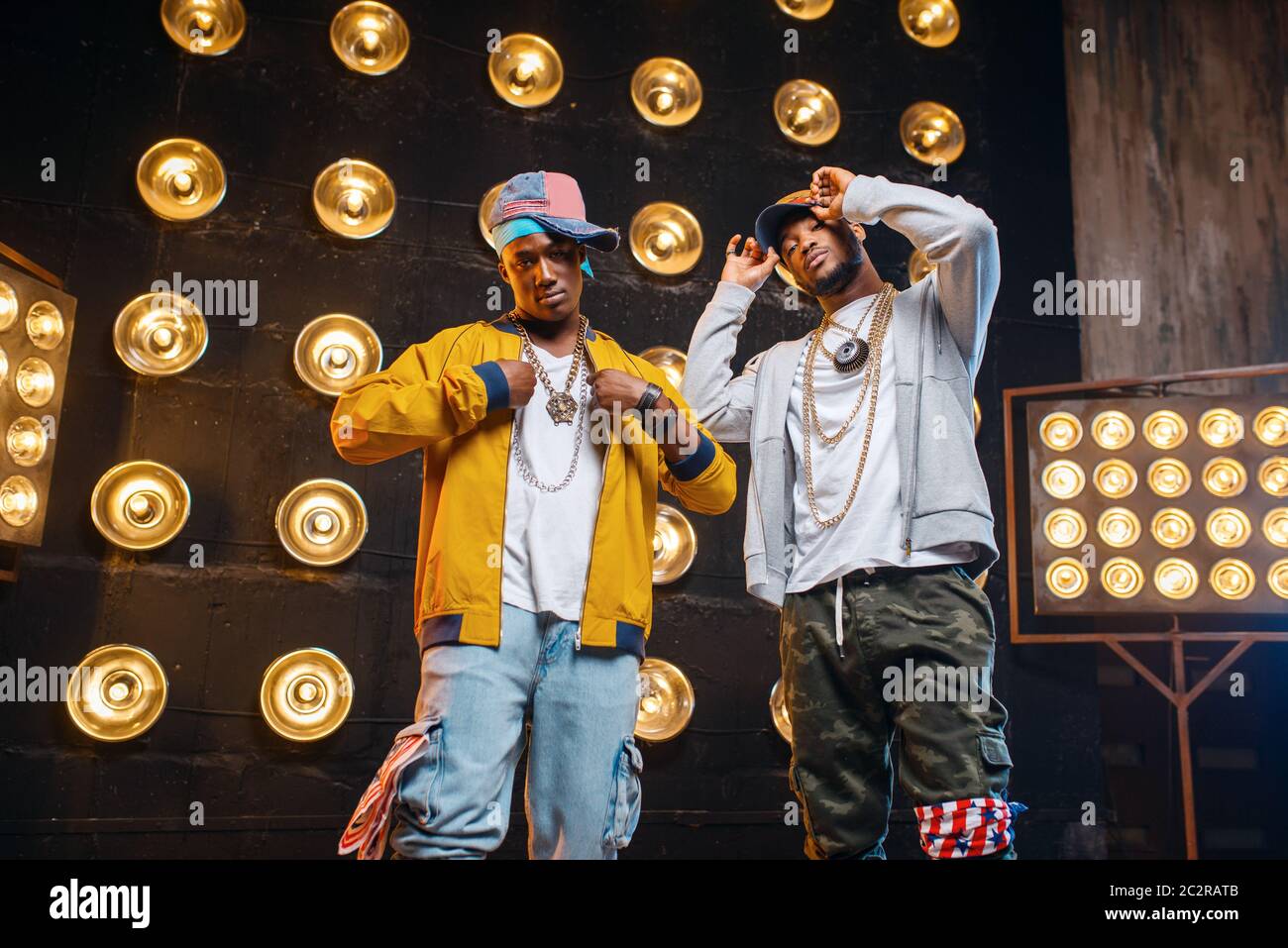 Black rappers in caps on stage with spotlights on background. Rap ...