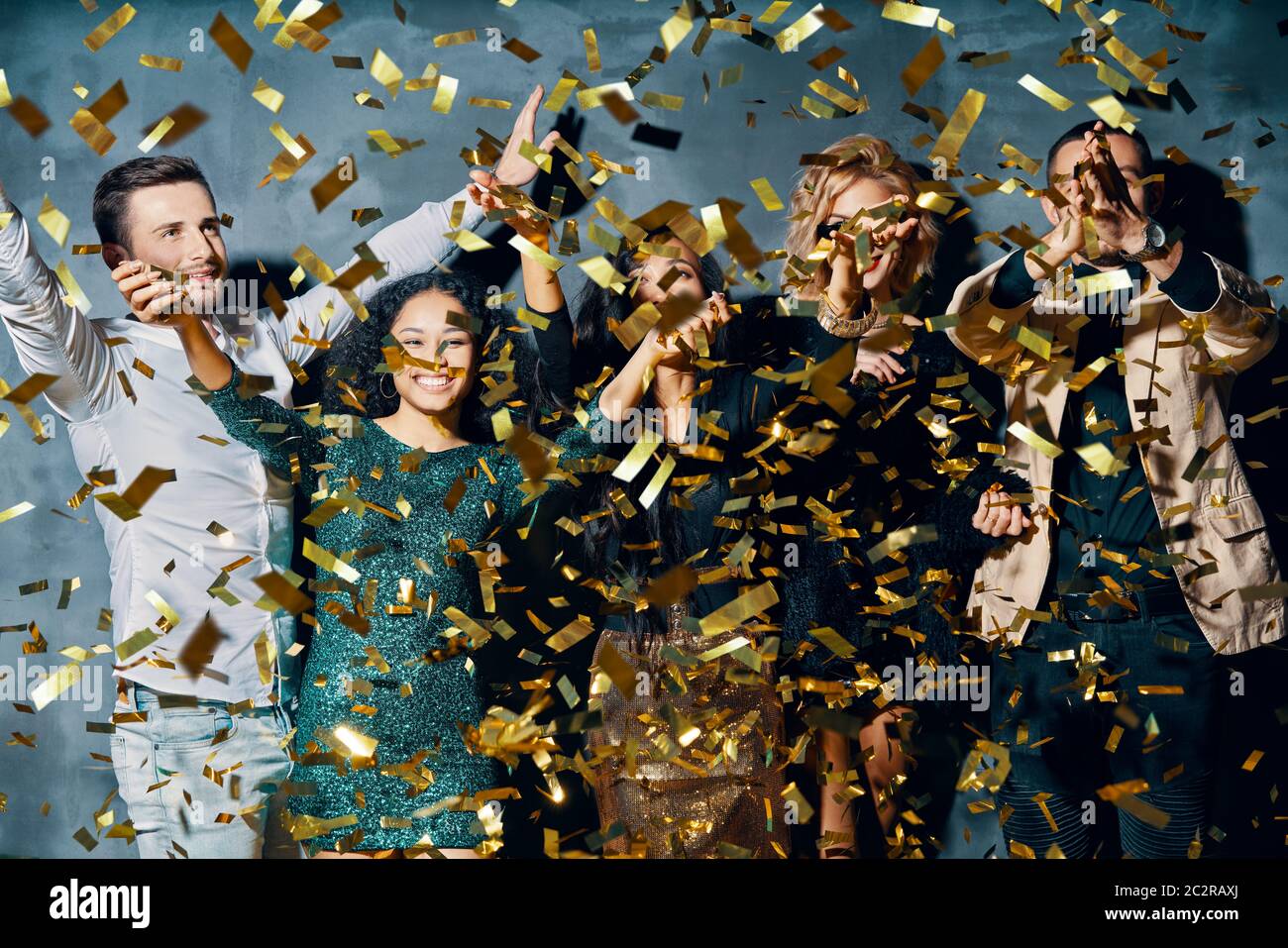 Happy young people dancing and having fun with confetti flying ...