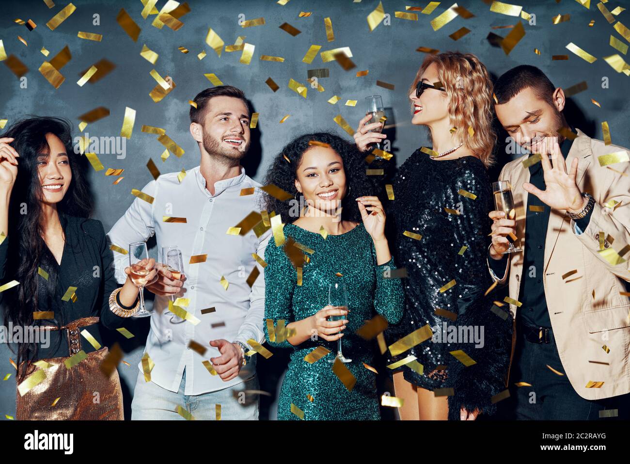 Happy young people dancing and having fun with confetti flying ...