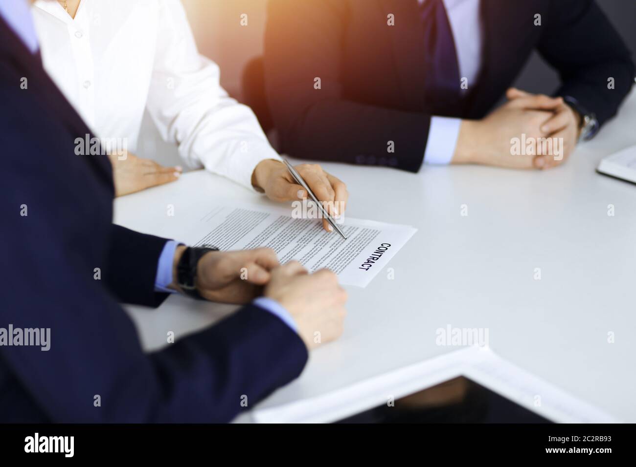 Group of business people, men and a woman, discuss details of a ...
