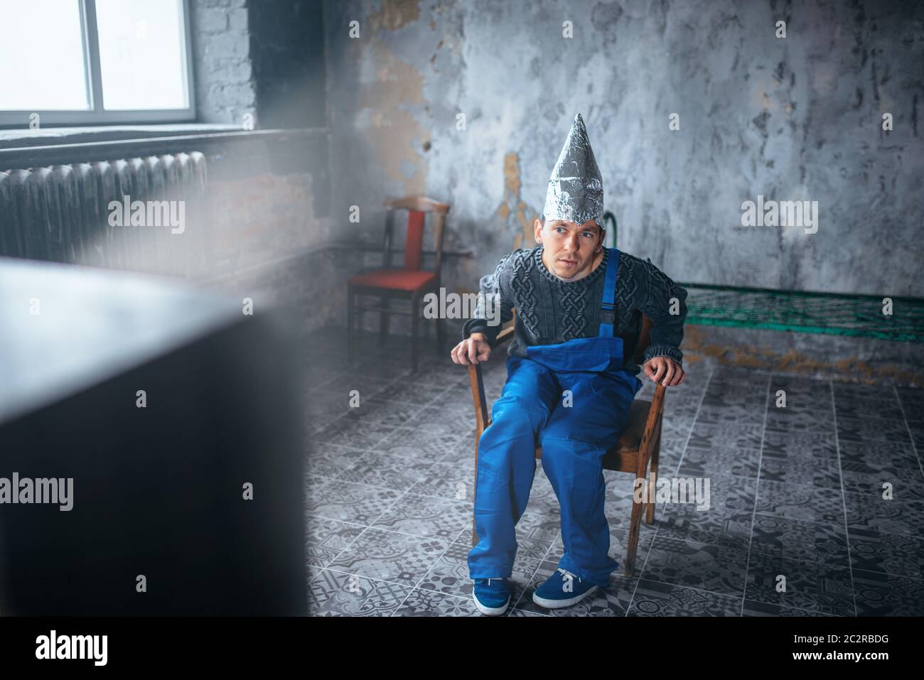 Strange man in aluminum foil helmet watch TV, mind protection, paranoia ...