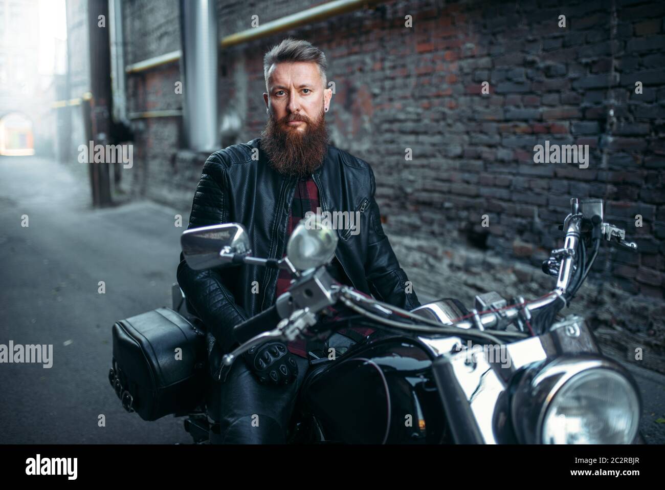 Biker in leather jacket sitting on classical chopper. Vintage bike ...