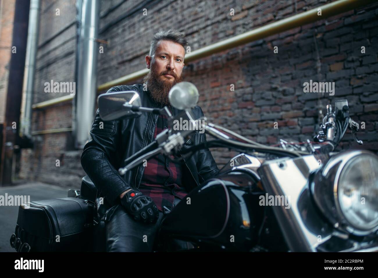 Biker in leather jacket sitting on classical chopper. Vintage bike ...