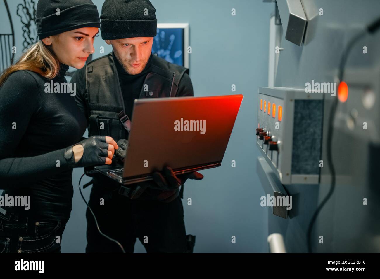 Bank robbery, two robbers with laptop trying to open the vault door ...