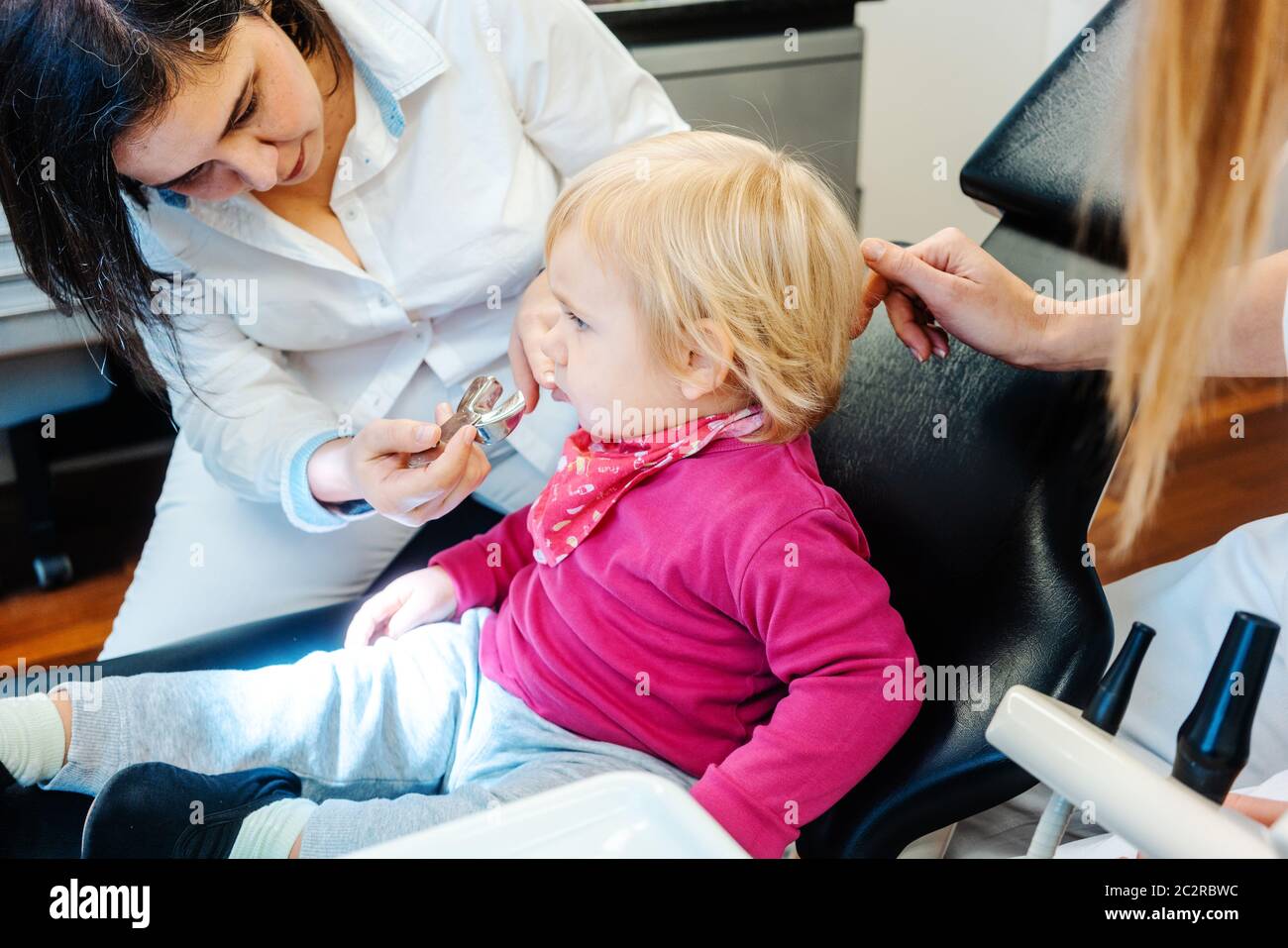 Friendly dentist checking teeth of a little child Stock Photo - Alamy