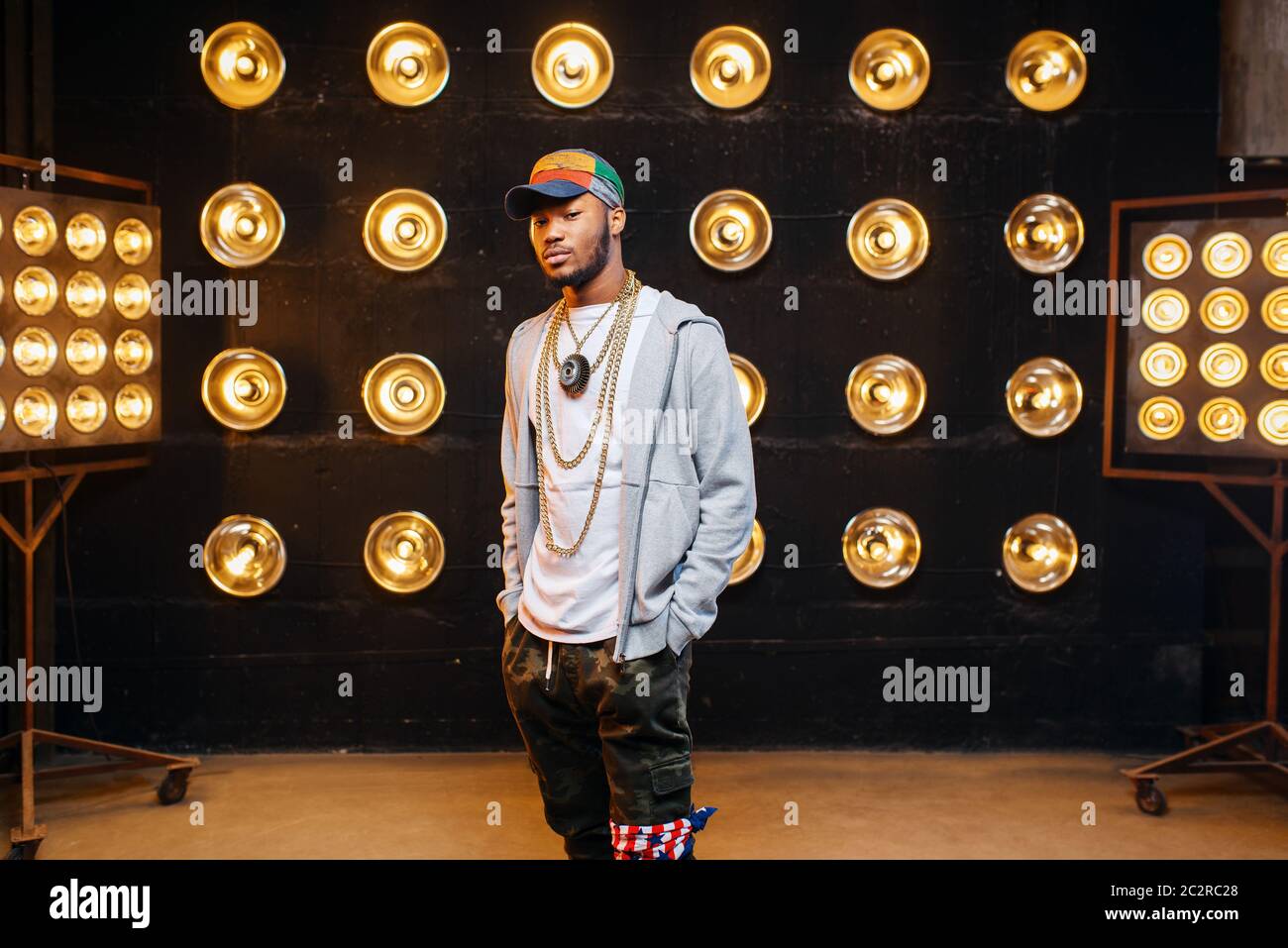 Black rapper in cap on stage with spotlights on background. Rap ...