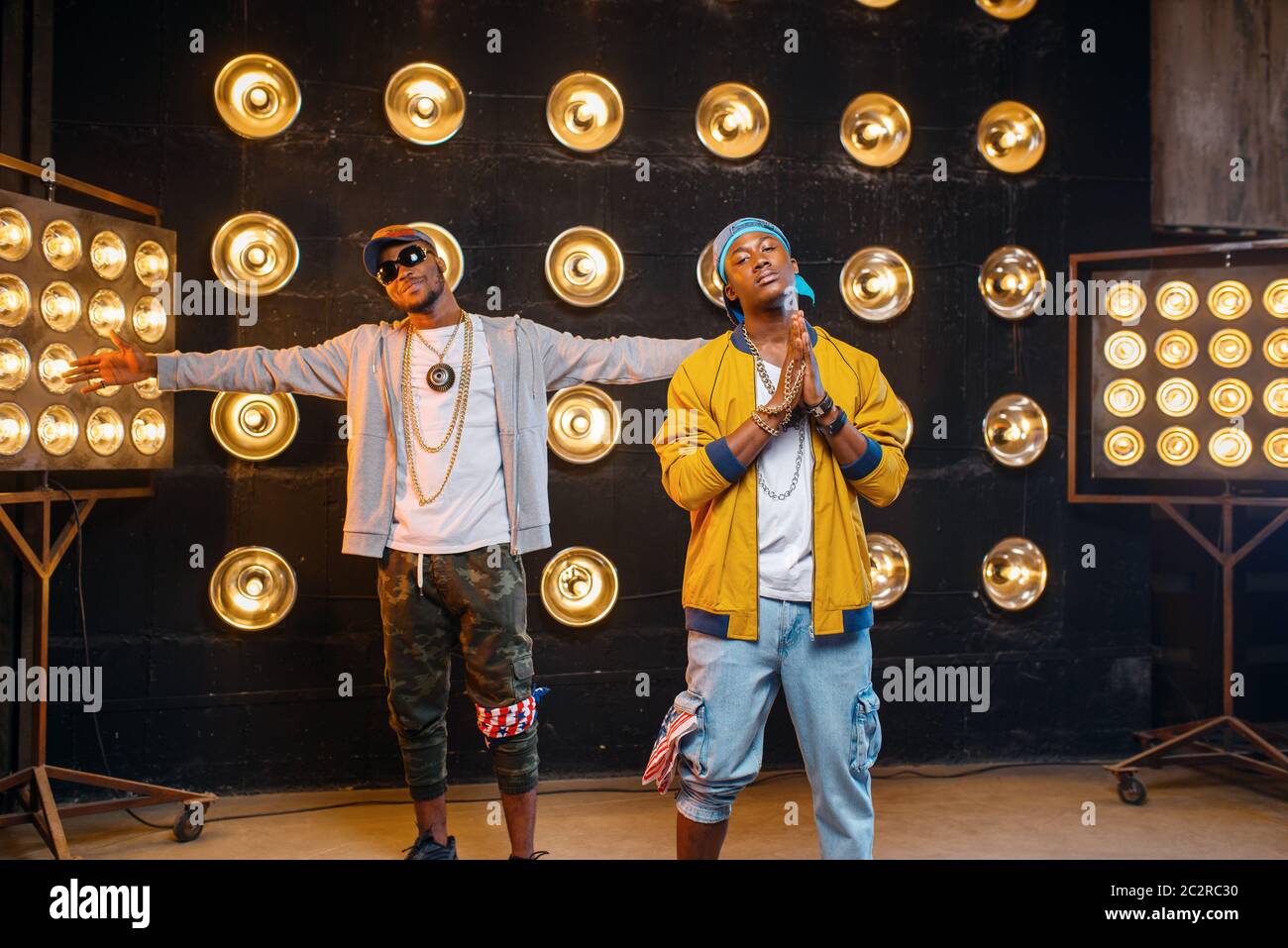 Two black rappers in caps, artists poses on stage with spotlights on ...