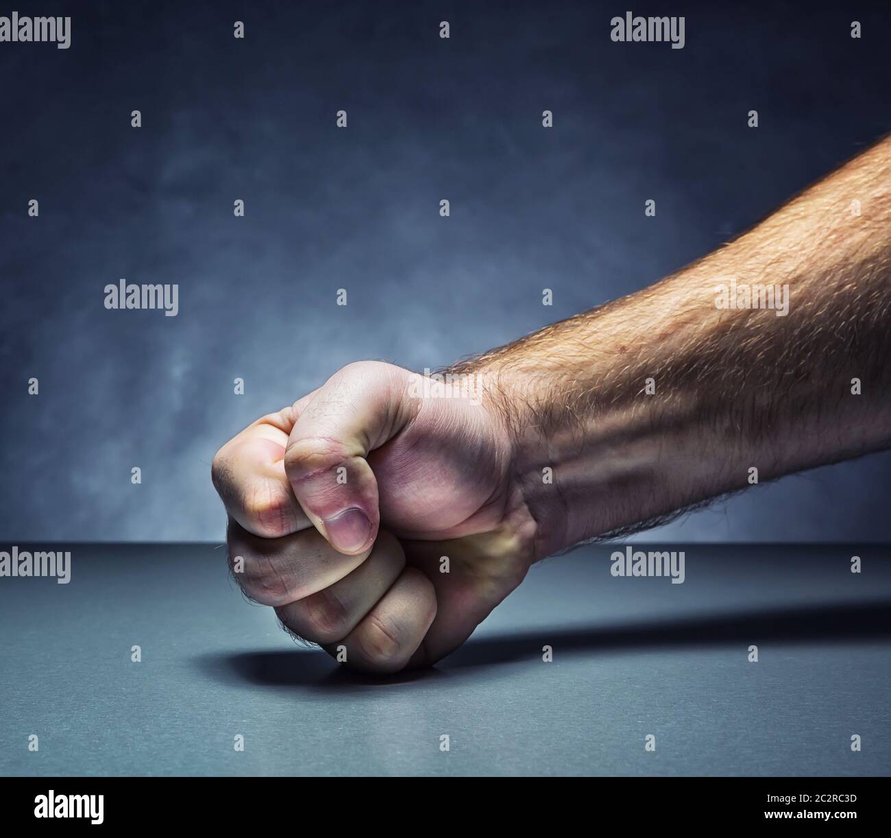 Male fist on the table in dark room Stock Photo - Alamy