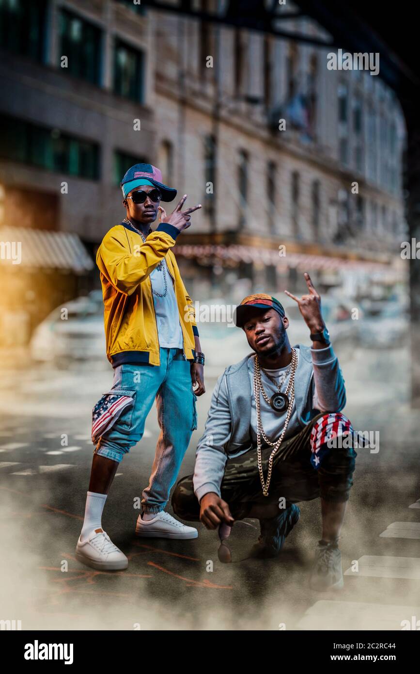 Two black rappers in caps, city street on background. Rap performers ...