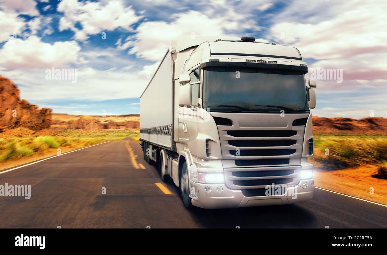 Freight truck on road in valley, front view. Heavy traffic on the ...