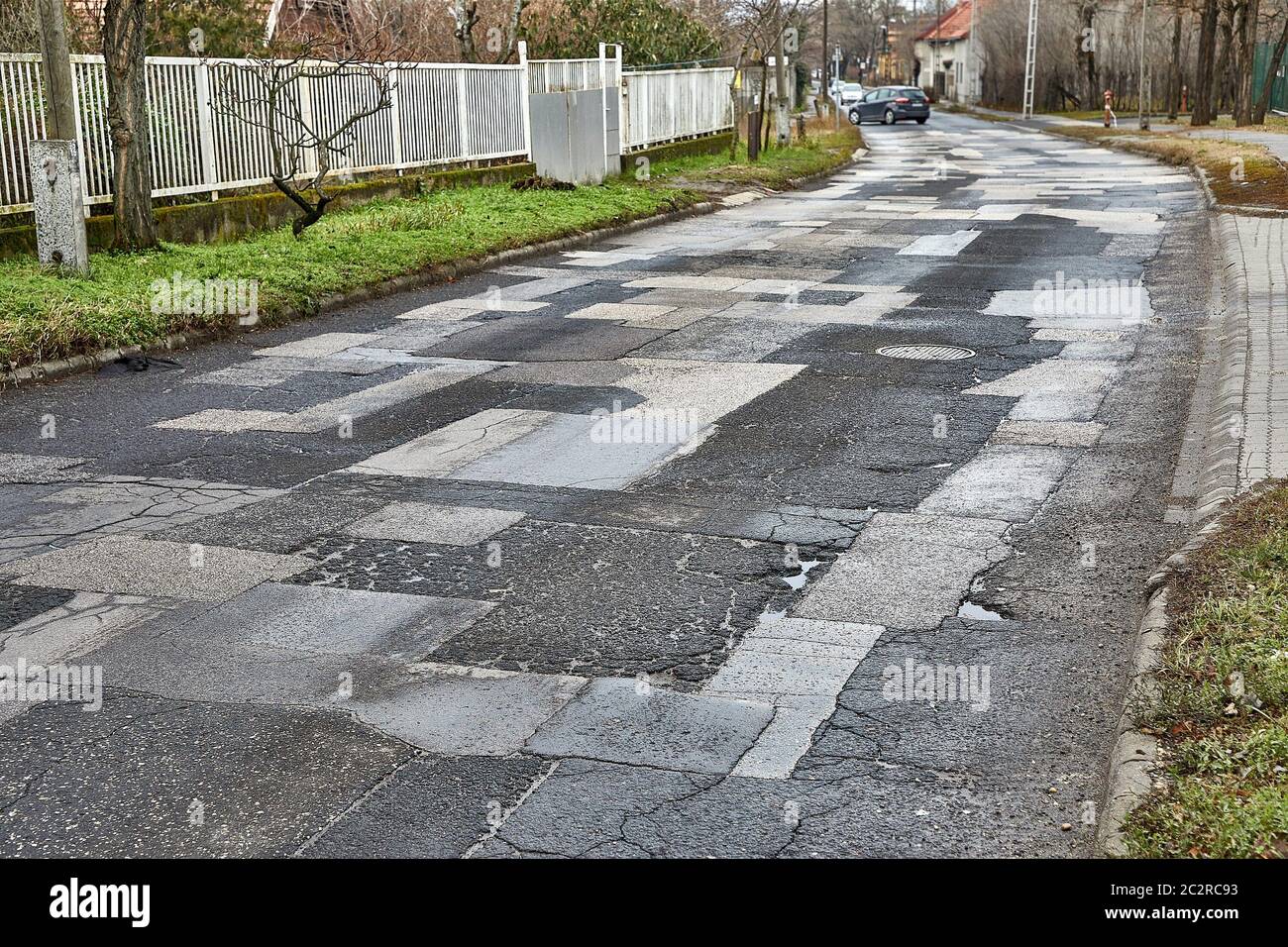 Extremely bad quality road with many patches, potholes Stock Photo - Alamy