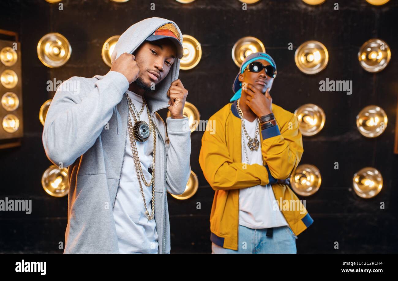 Two black rappers in caps on stage with spotlights on background. Rap ...