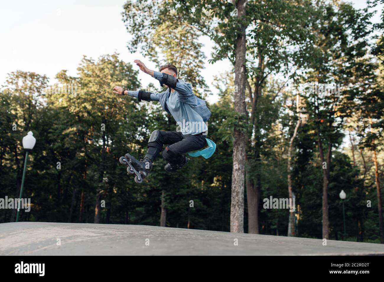 Roller skating, young male skater jumping on ramp. Urban roller-skating ...