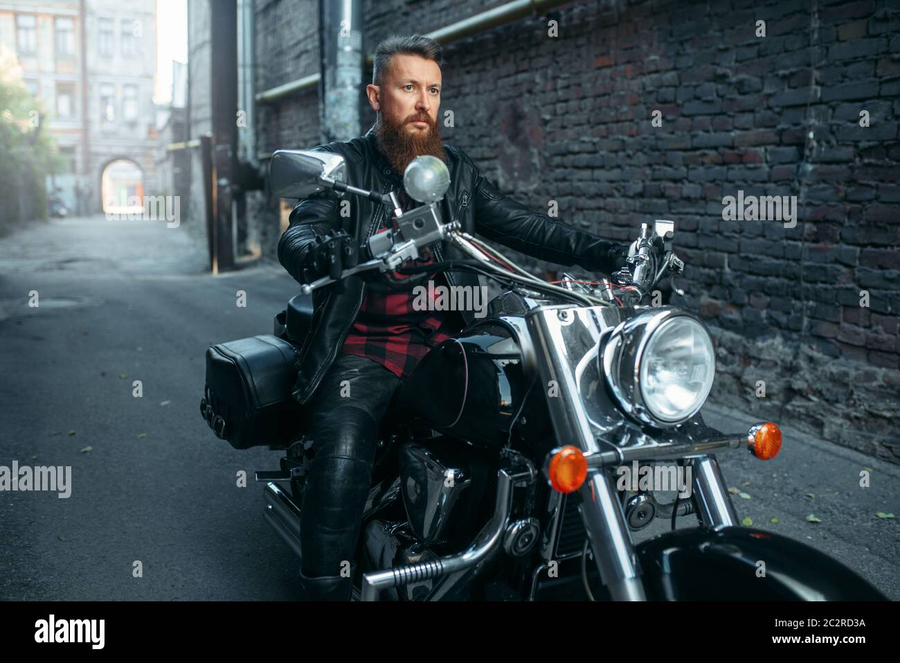 Motorcyclist in leather jacket poses on classical chopper. Vintage bike ...