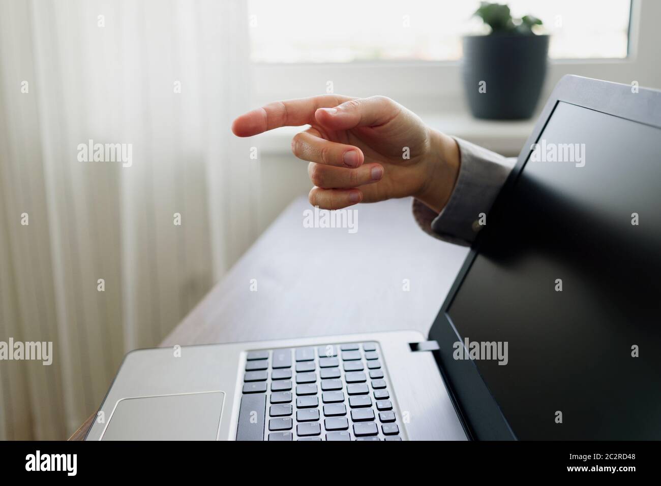 Hand pointing finger from laptop or internet online Stock Photo - Alamy
